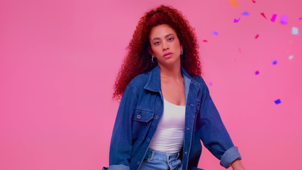 Over a vibrant pink background a young beautiful woman stand still ...