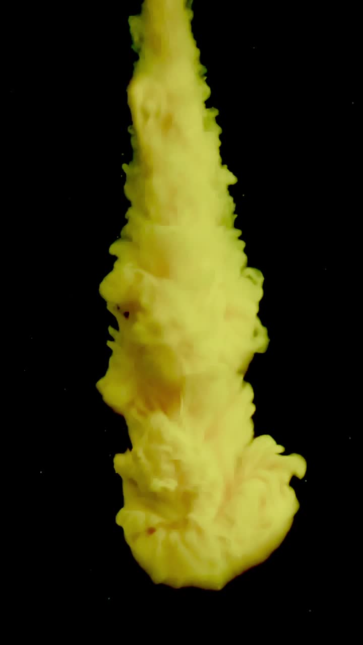 Vertical video of a vibrant yellow substance injected from top to ...