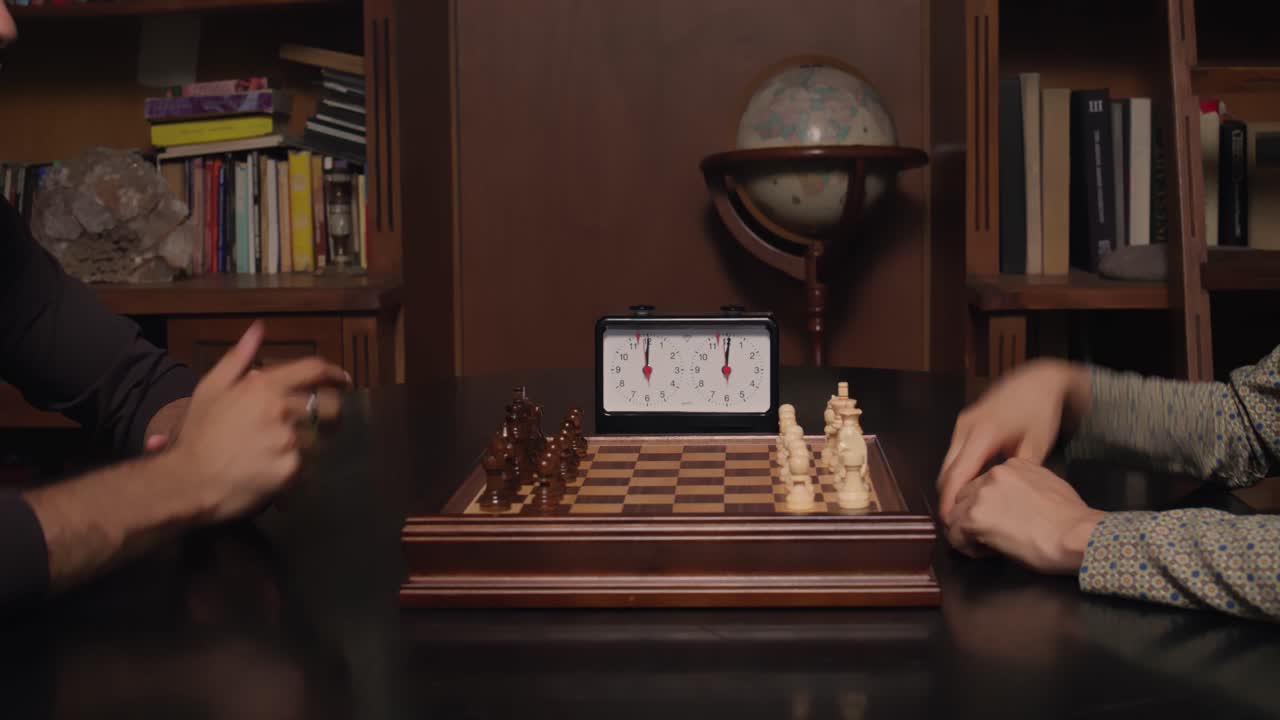 The players shake hands above the chess board and start to move the pieces - Free Stock Video