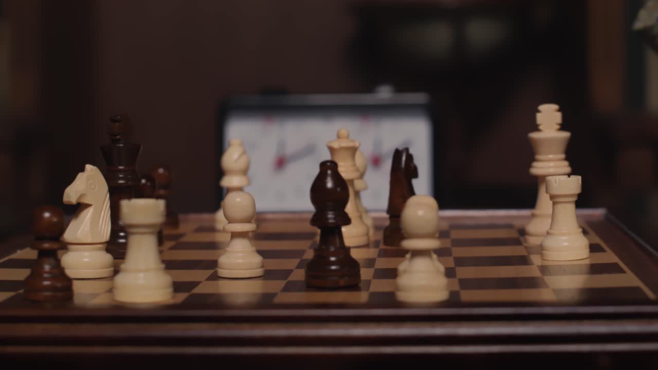 A hand moves a white chess piece and takes a black one to the side of the board - Free Stock Video