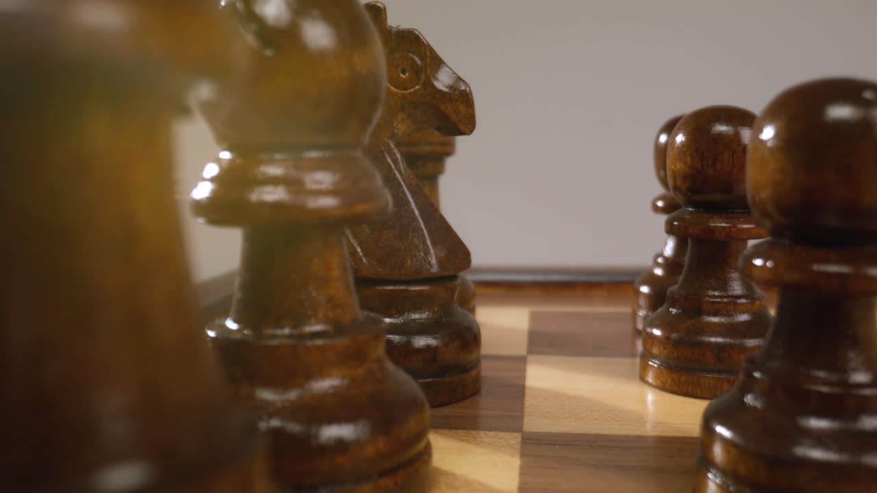 A close-up pan shot reveals the intricate details of wooden chess ...