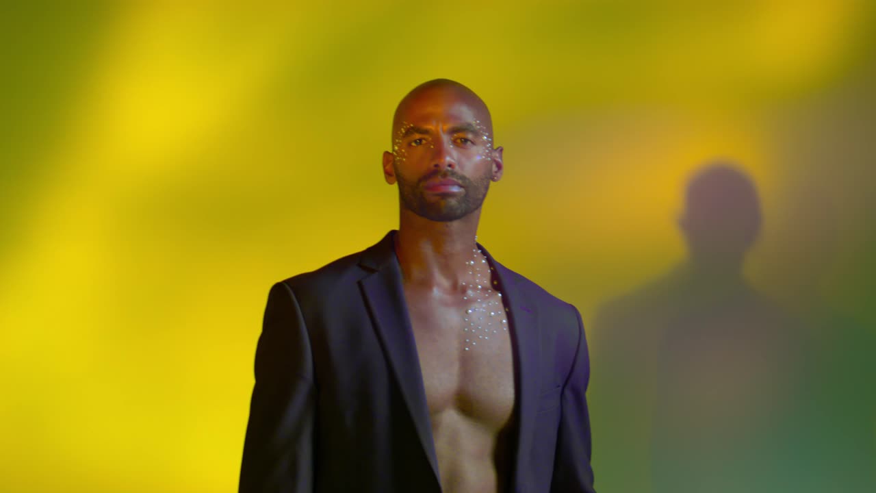 Man in a suit with vibrant, colorful lighting effects. - Free Stock Video