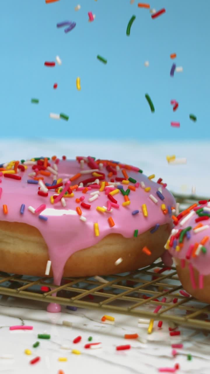 Sprinkles Falling onto Freshly Baked Donuts - Free Stock Video