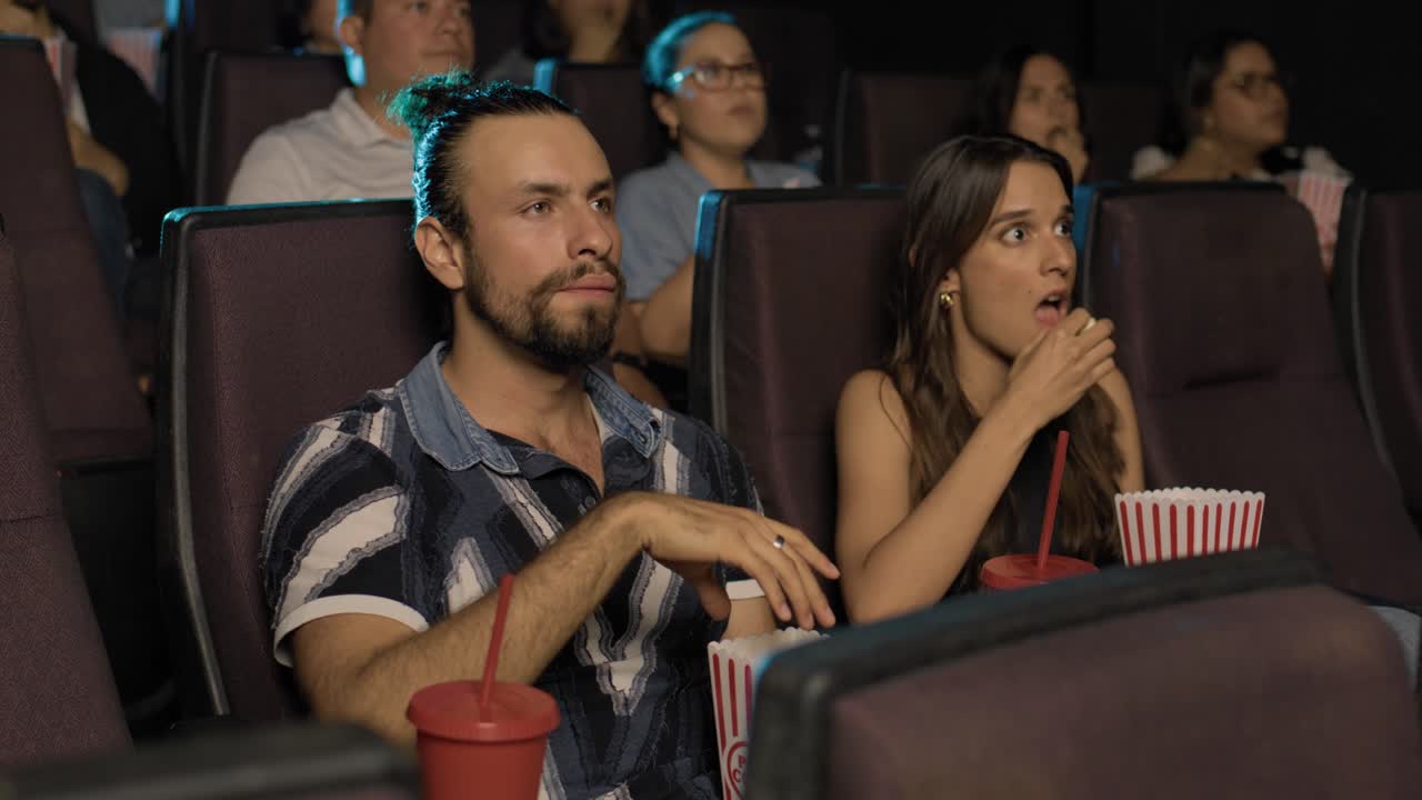 Couple enjoying a horror movie at the theater - Free Stock Video