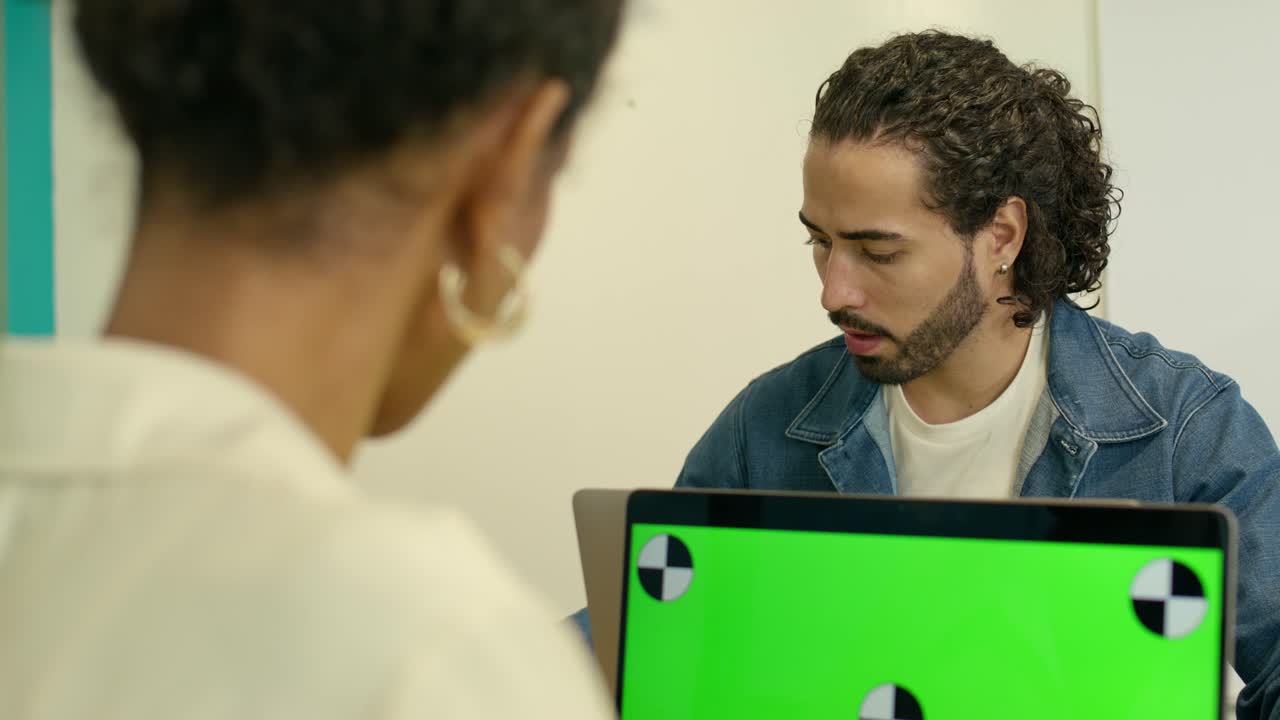 Two people looking at a green screen laptop - Free Stock Video