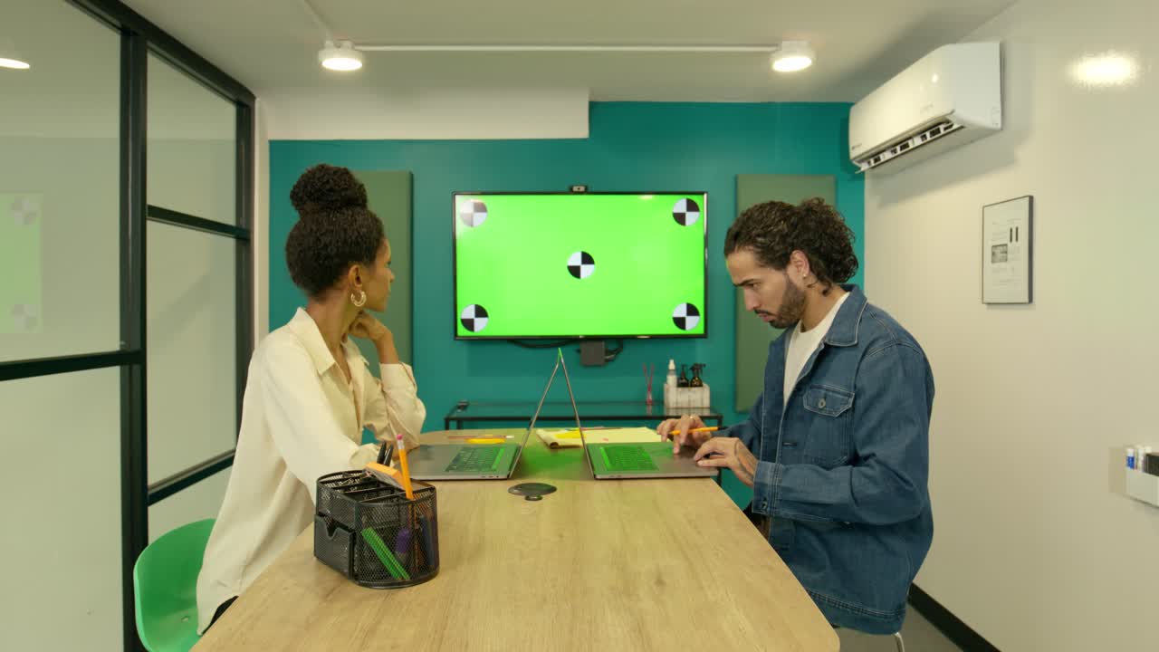 Two people discussing in a meeting room with a green screen - Free ...