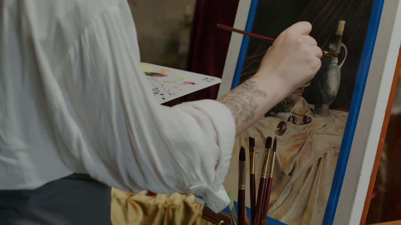 Artist painting a fruit still life tableau - Free Stock Video