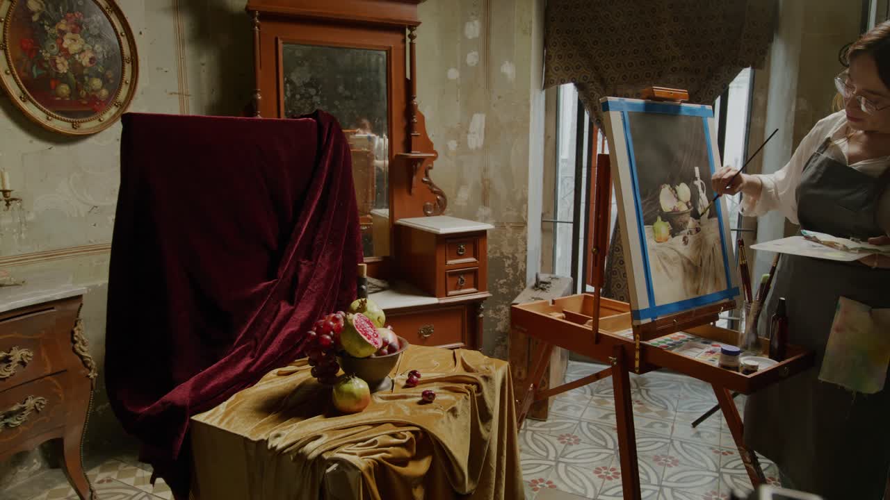 Artist painting a still life in a cozy studio - Free Stock Video