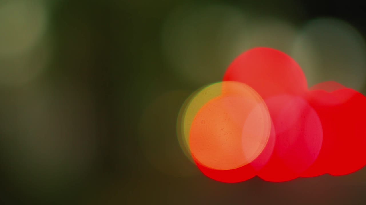 Dark background with big red bokeh lights in the distance - Free Stock Video