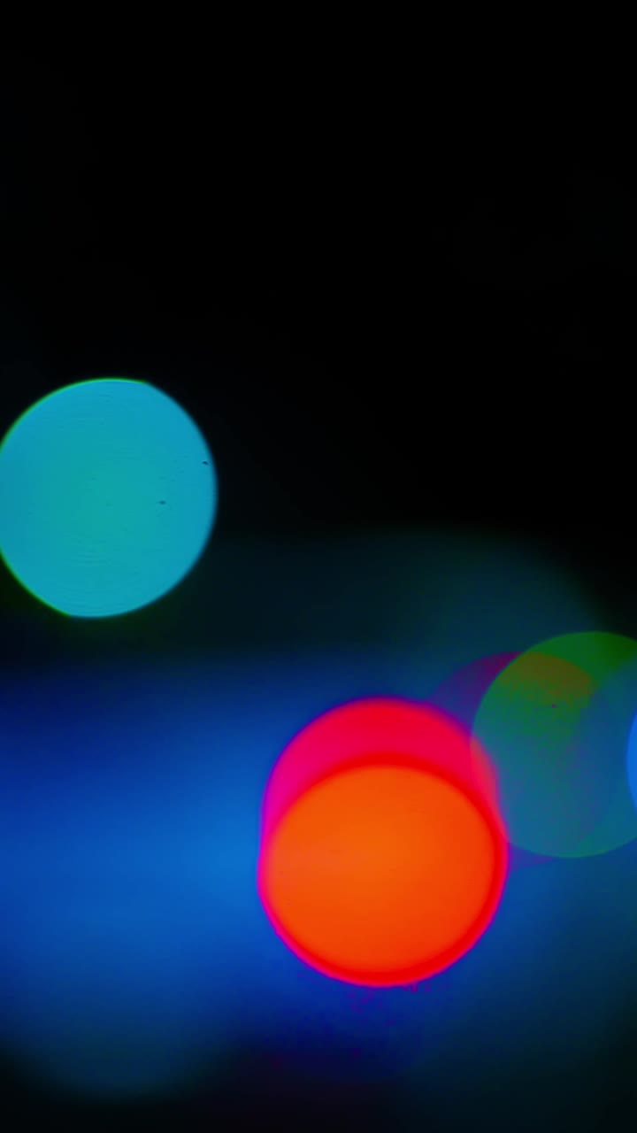 Vertical video colorful bokeh lights on black background - Free Stock Video