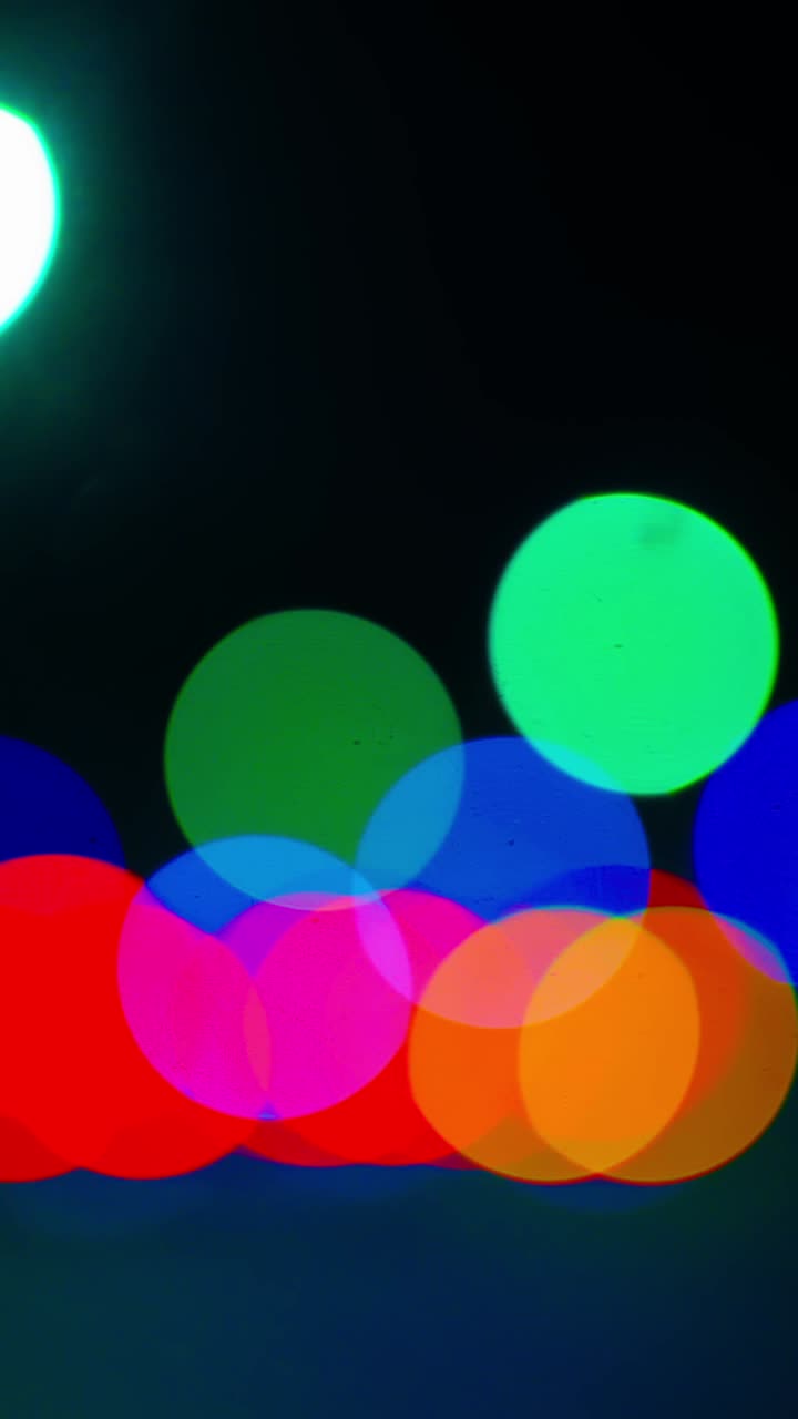 Vertical video of colorful bokeh lights in the dark - Free Stock Video