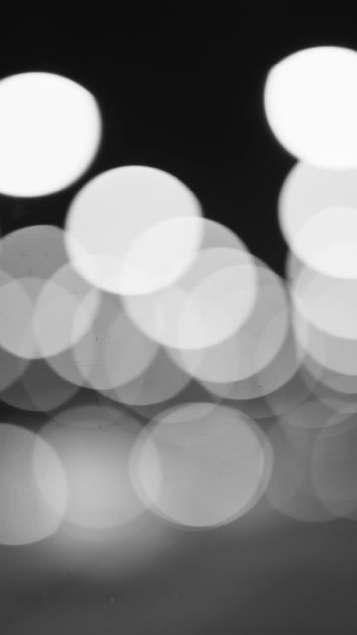 Vertical video scene of bokeh lights expanding against a dark ...