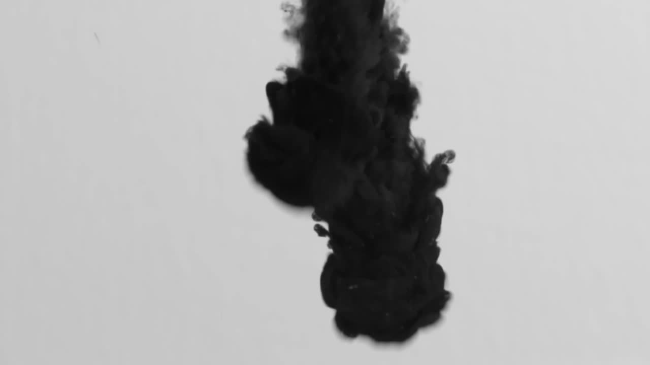 Black ink enter a transparent liquid medium with force creating a ...