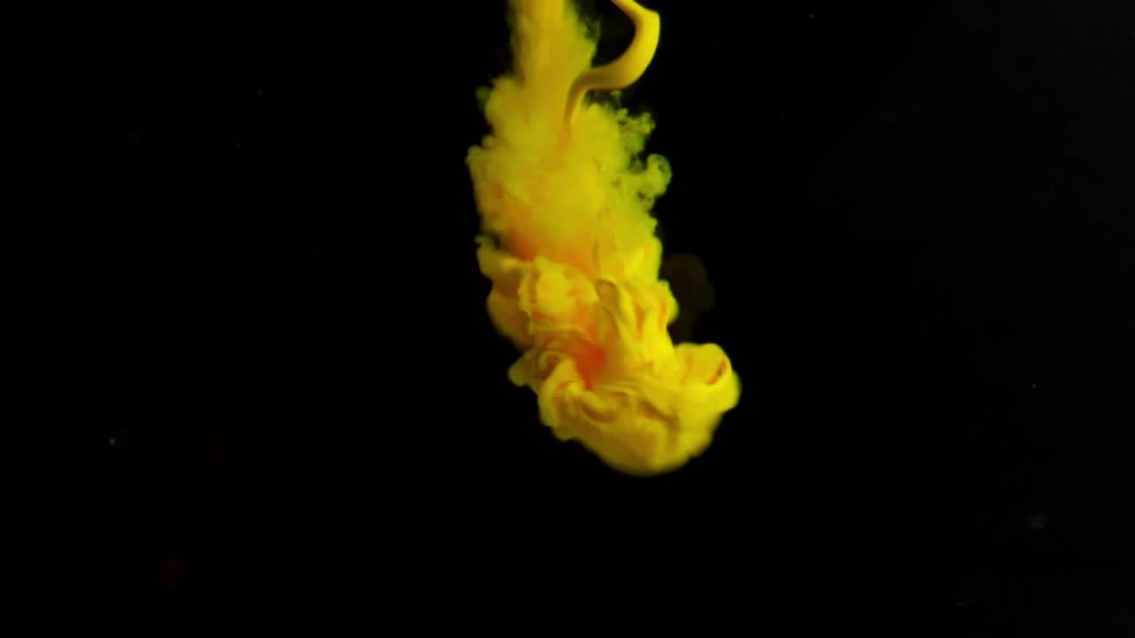 A vibrant yellow and pink substance, likely smoke or ink, dispersing in ...