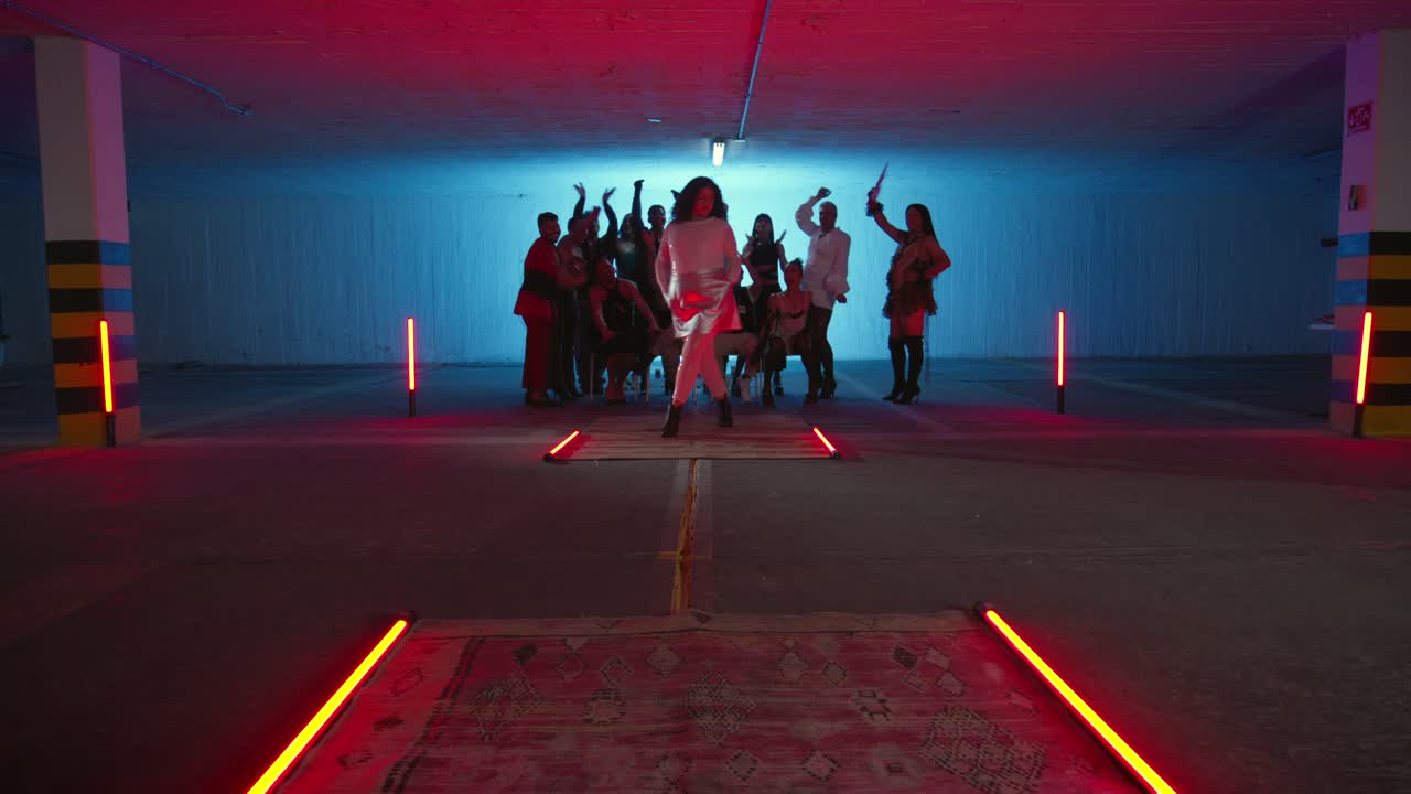 A LGBTQ person dressed in white does a catwalk towards the camera in a ...