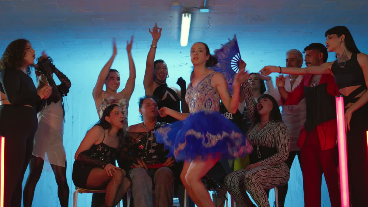A LGBTQ dancer in a colorful outfit performs energetically at the ...