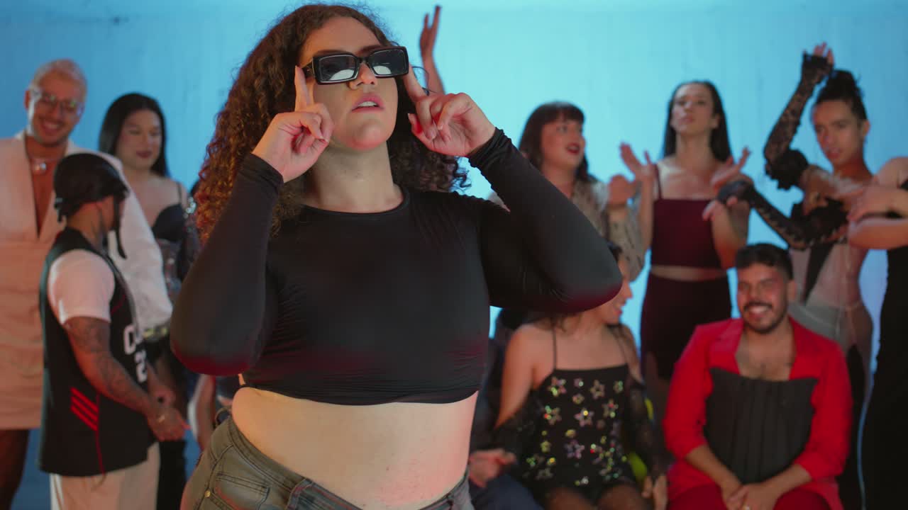 A young LGBTQ member dancing at a celebration with vibrant lighting and ...