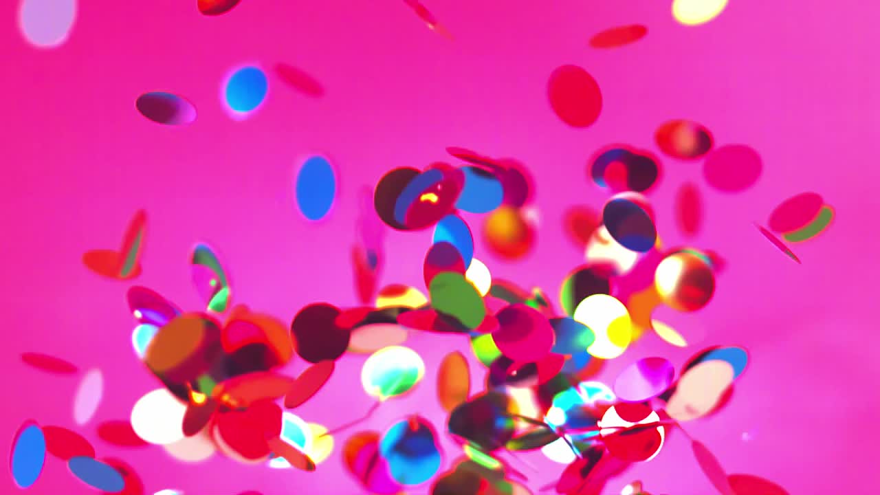 Close up shot of multicolored metallic confetti falling in slow motion ...