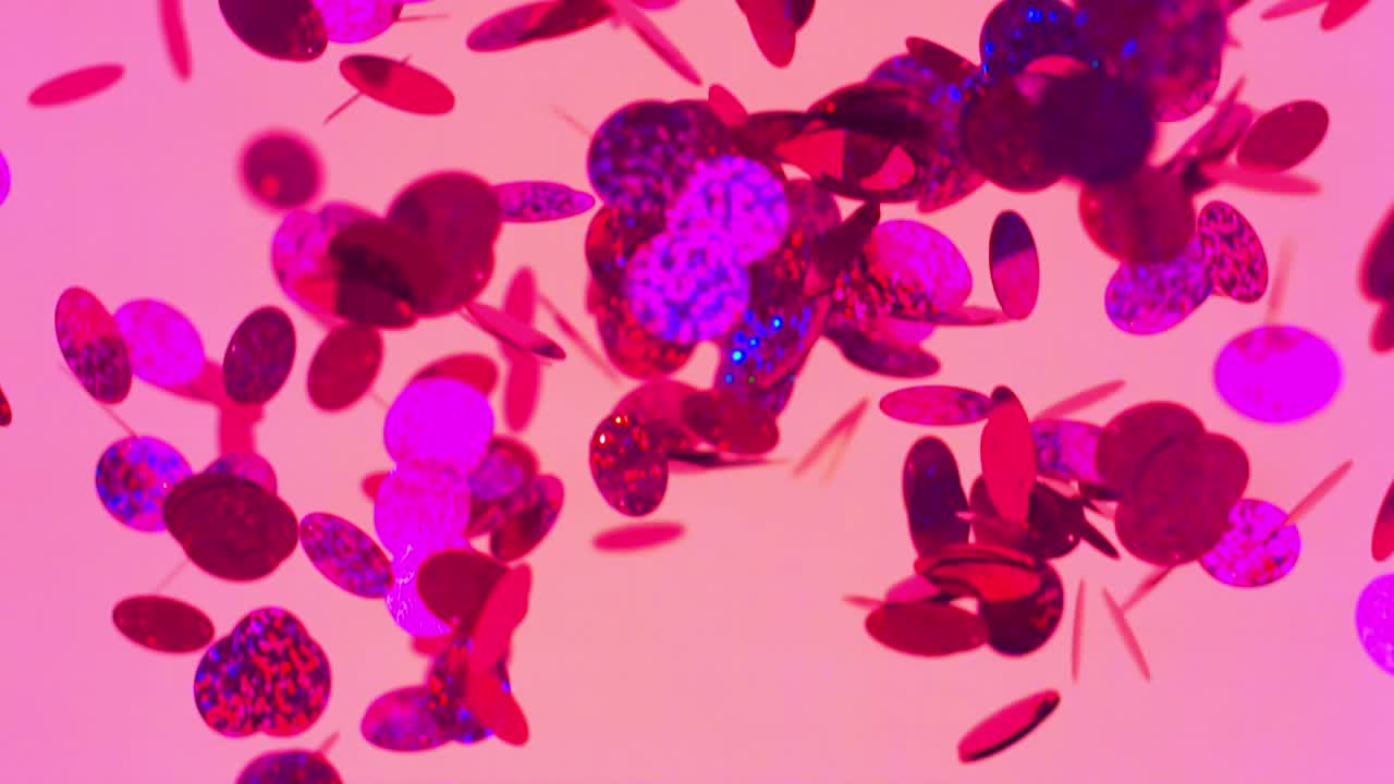 Circular shaped confetti with metallic finish falling over a vibrant ...