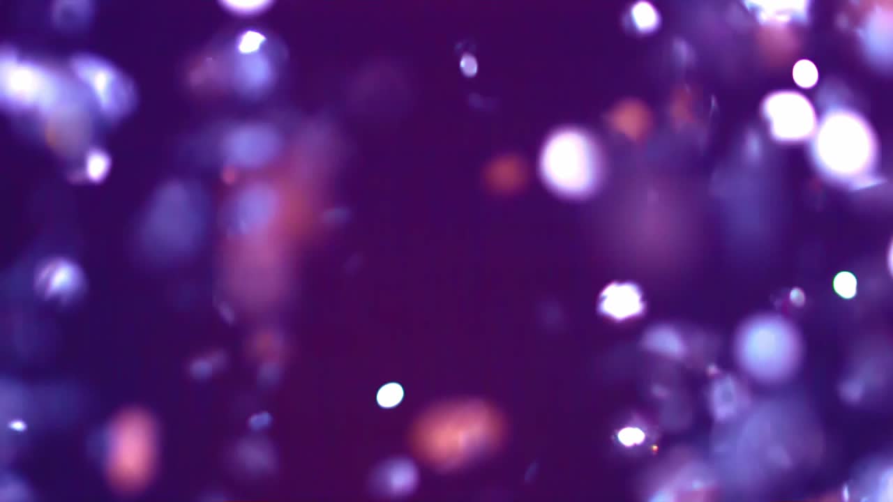 Abstract shapes falling in slow motion over a purple background ...