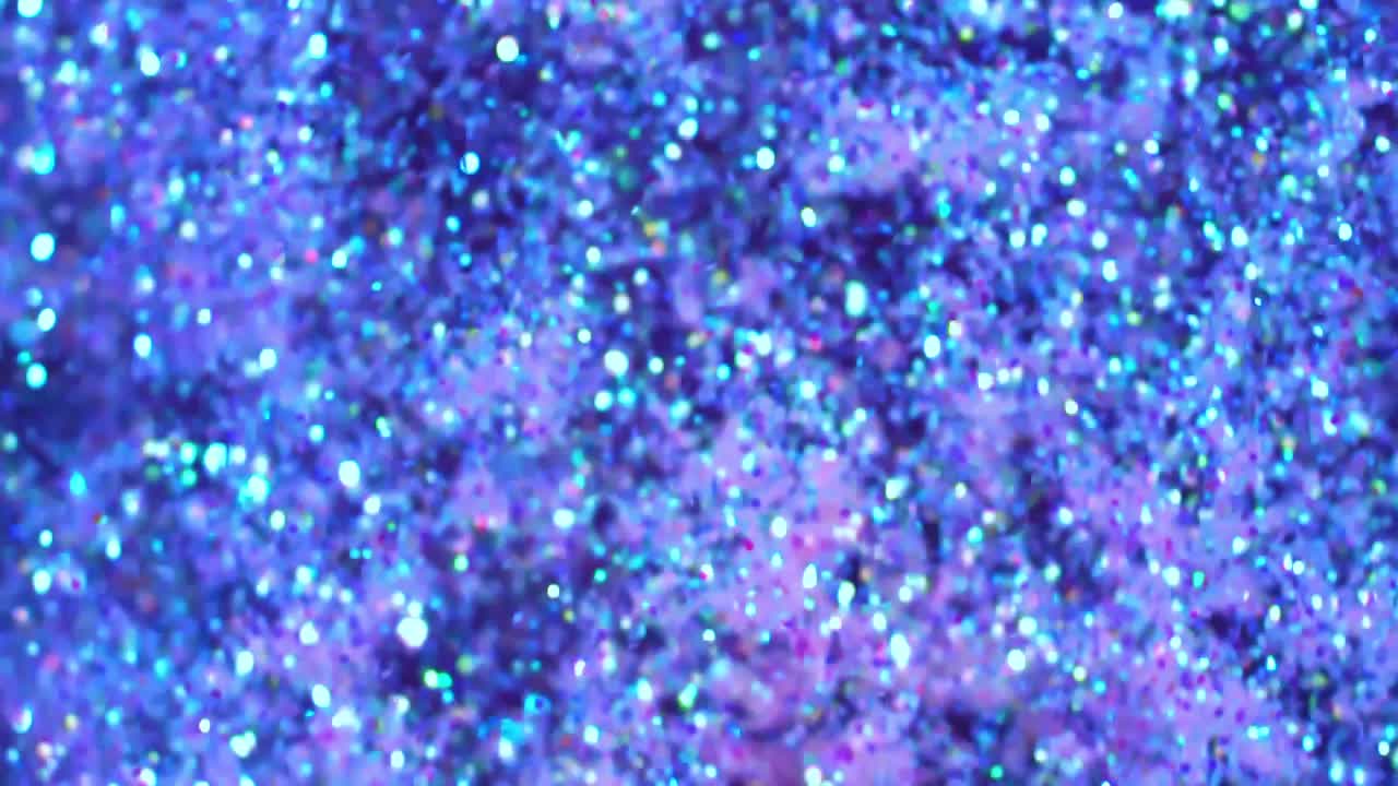 A mesmerizing close up shot of shimmering blue confetti falling in slow ...