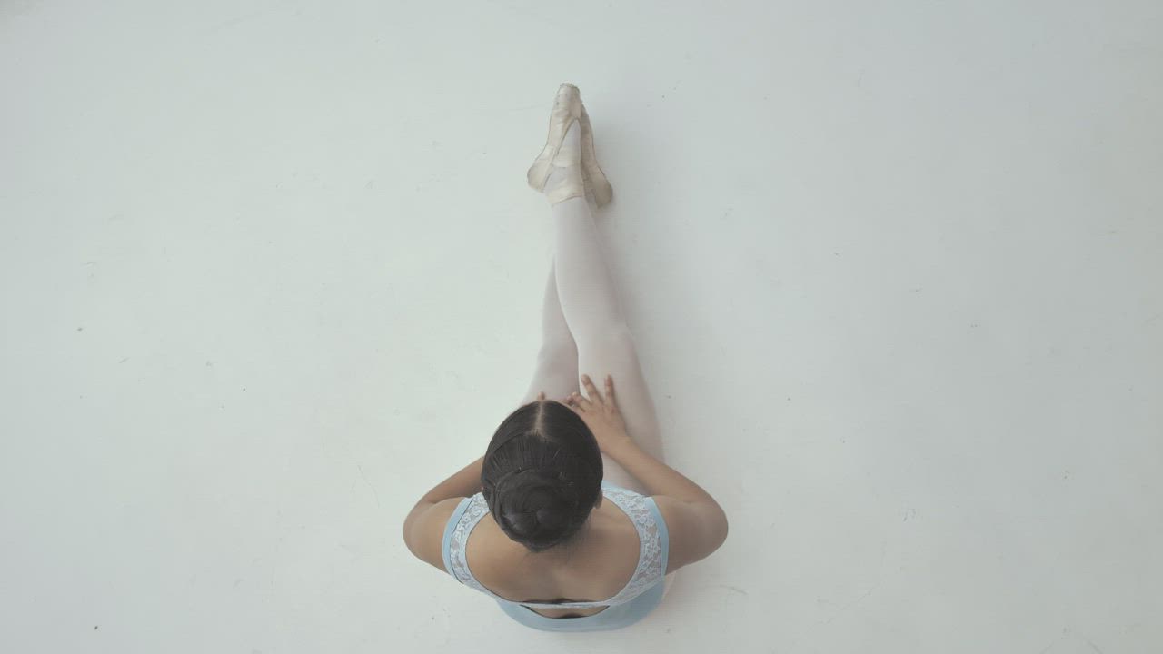 Top view of a ballerina while stretching - Free Stock Video