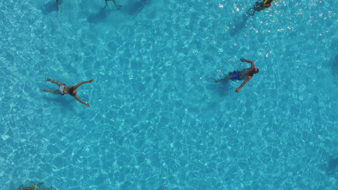 Aerial view of people enjoying the swimming pool - Free Stock Video
