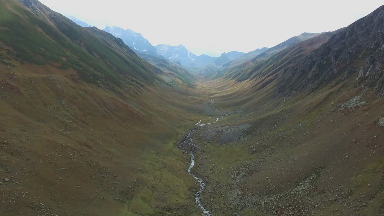 A small river at the bottom of the valley - Free Stock Video