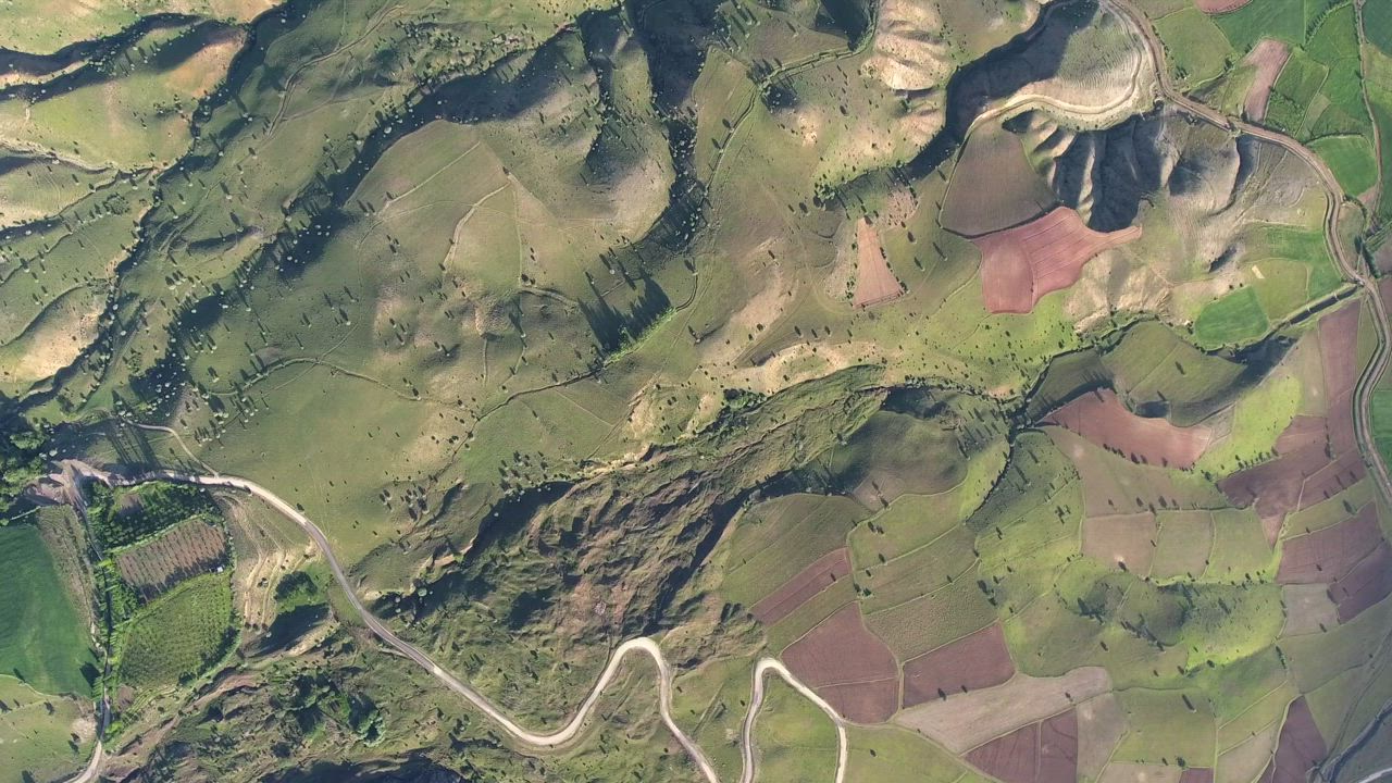 Aerial view of mountain geography, a town, and a lake - Free Stock Video
