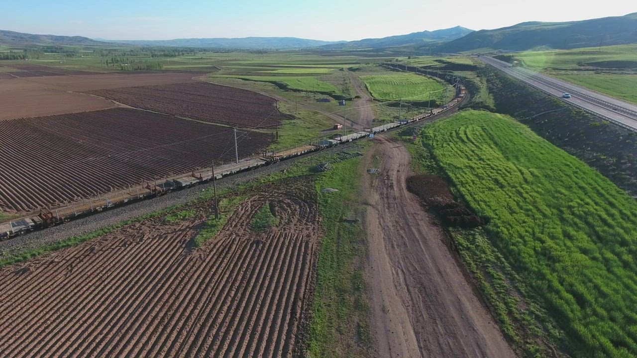 Freight train moving through agricultural fields - Free Stock Video