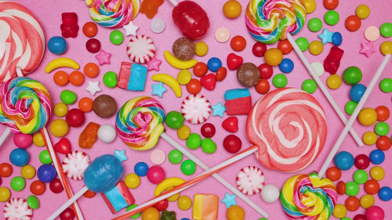 Covering a pink background with candies in stop motion - Free Stock Video