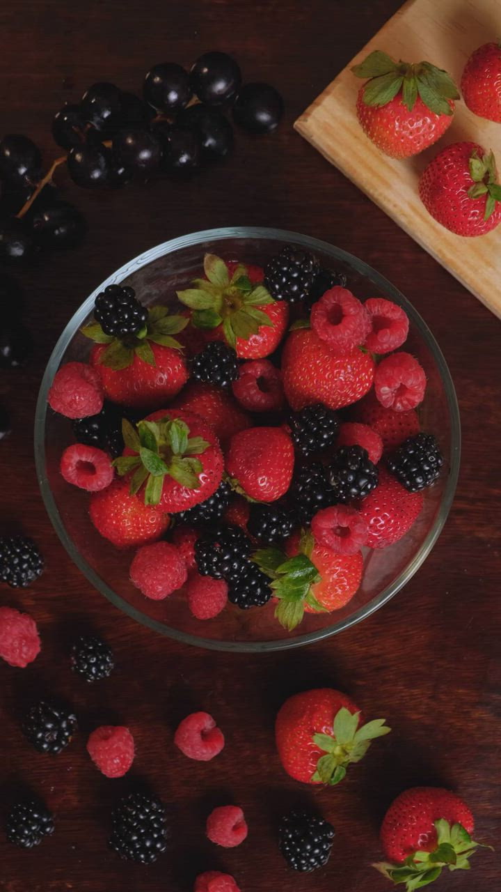 Red berries served in a bowl on a wooden table - Free Stock Video