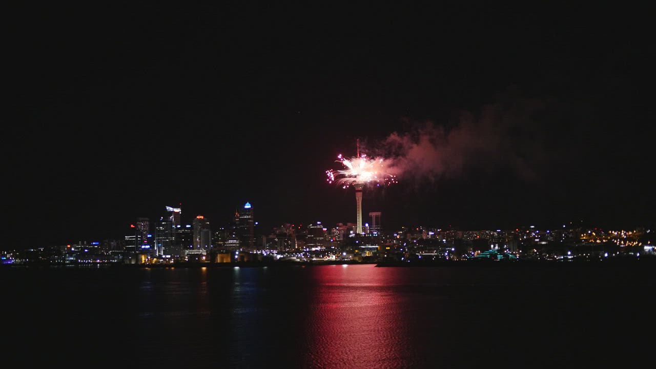 Fireworks in the top of a tower and the city lights - Free Stock Video