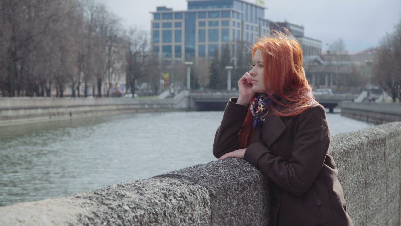 Woman looking out over a river - Free Stock Video