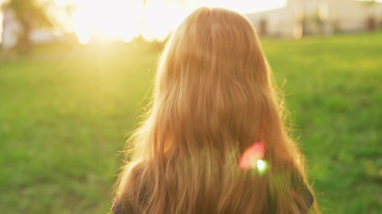 Girl walking outside looking backwards - Free Stock Video