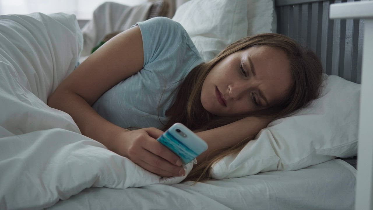 Woman using her phone in bed - Free Stock Video