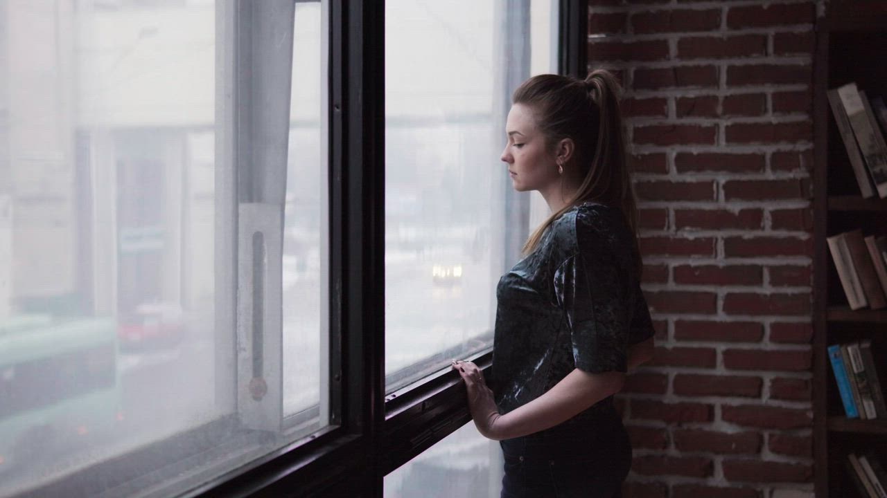 Sad woman looking out of the window - Free Stock Video