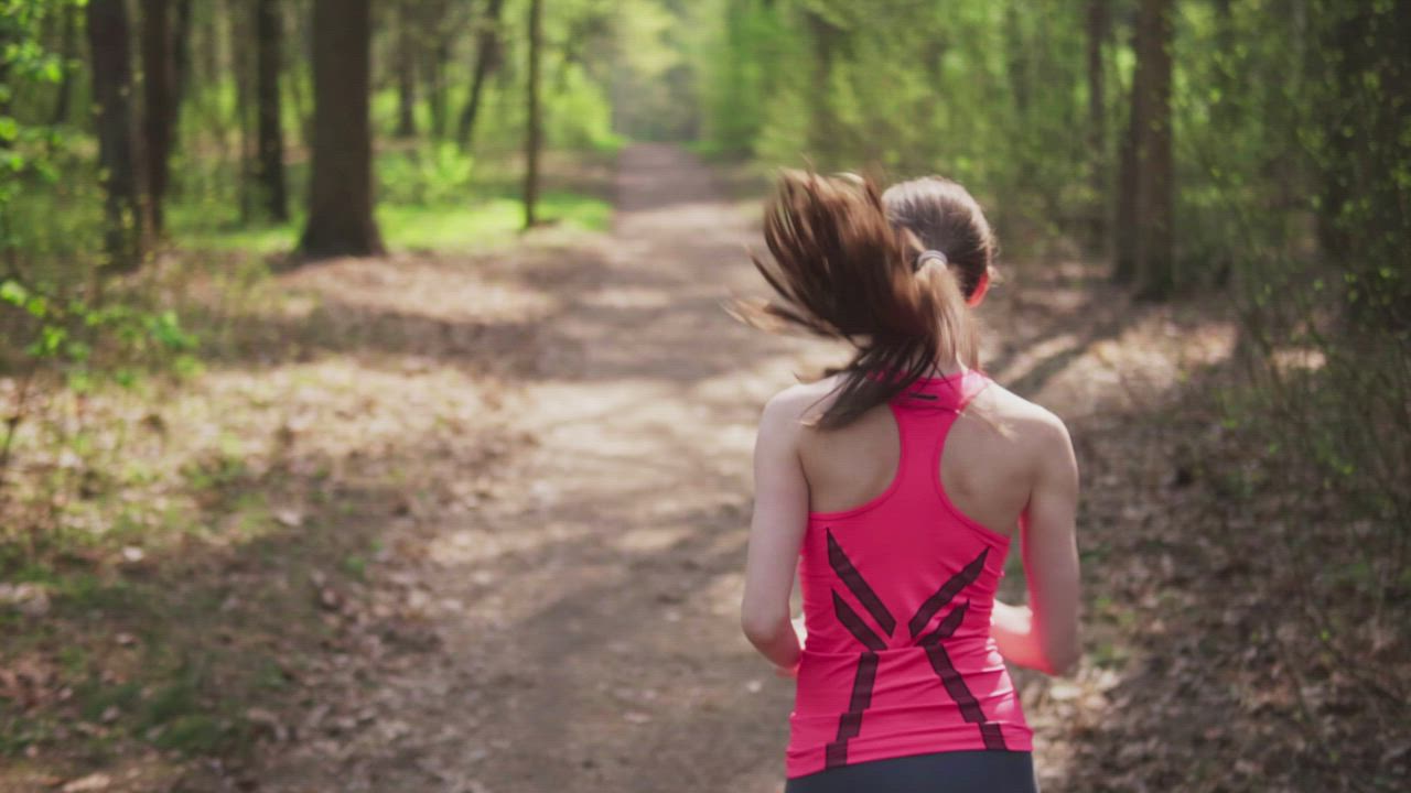 Woman running down a country path - Free Stock Video