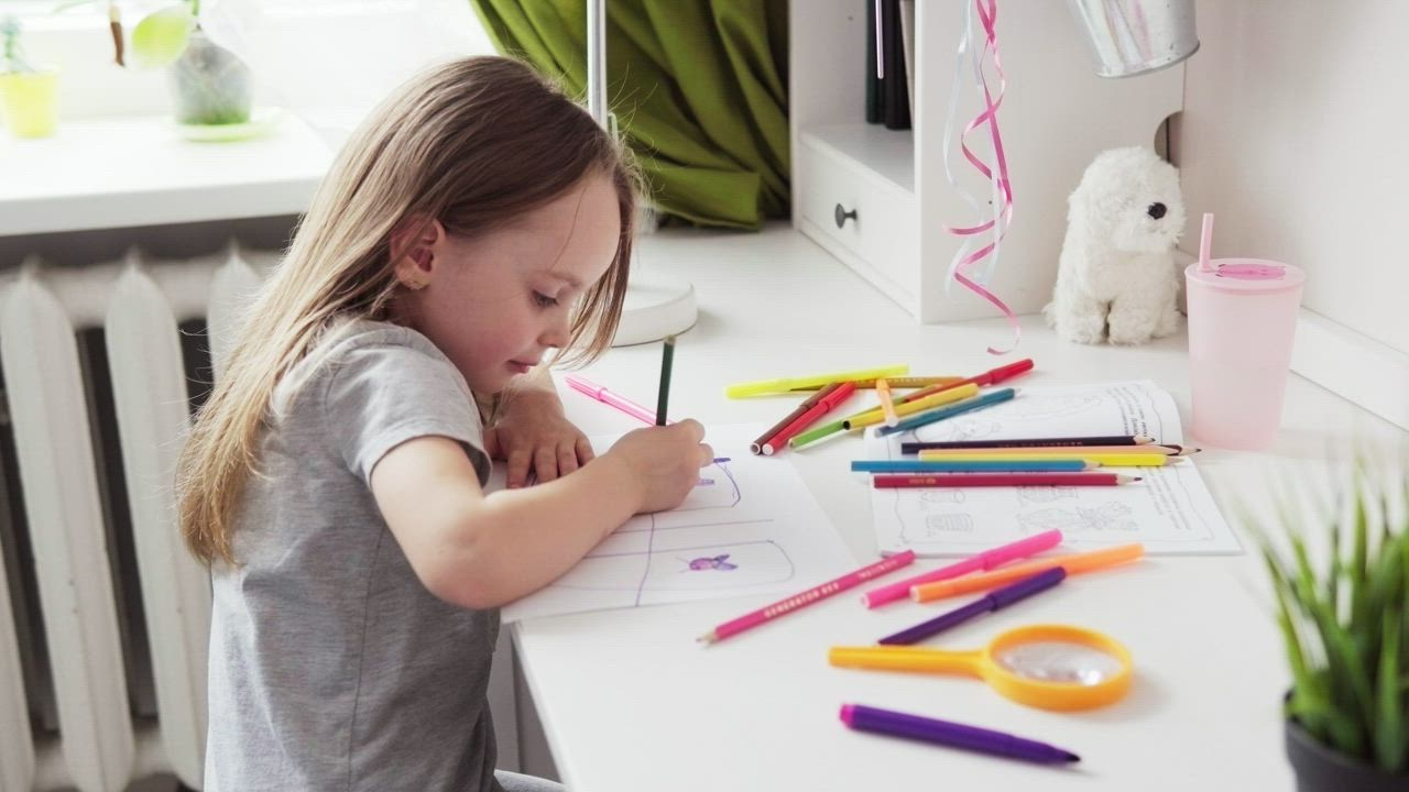 Child sitting at her desk drawing - Free Stock Video