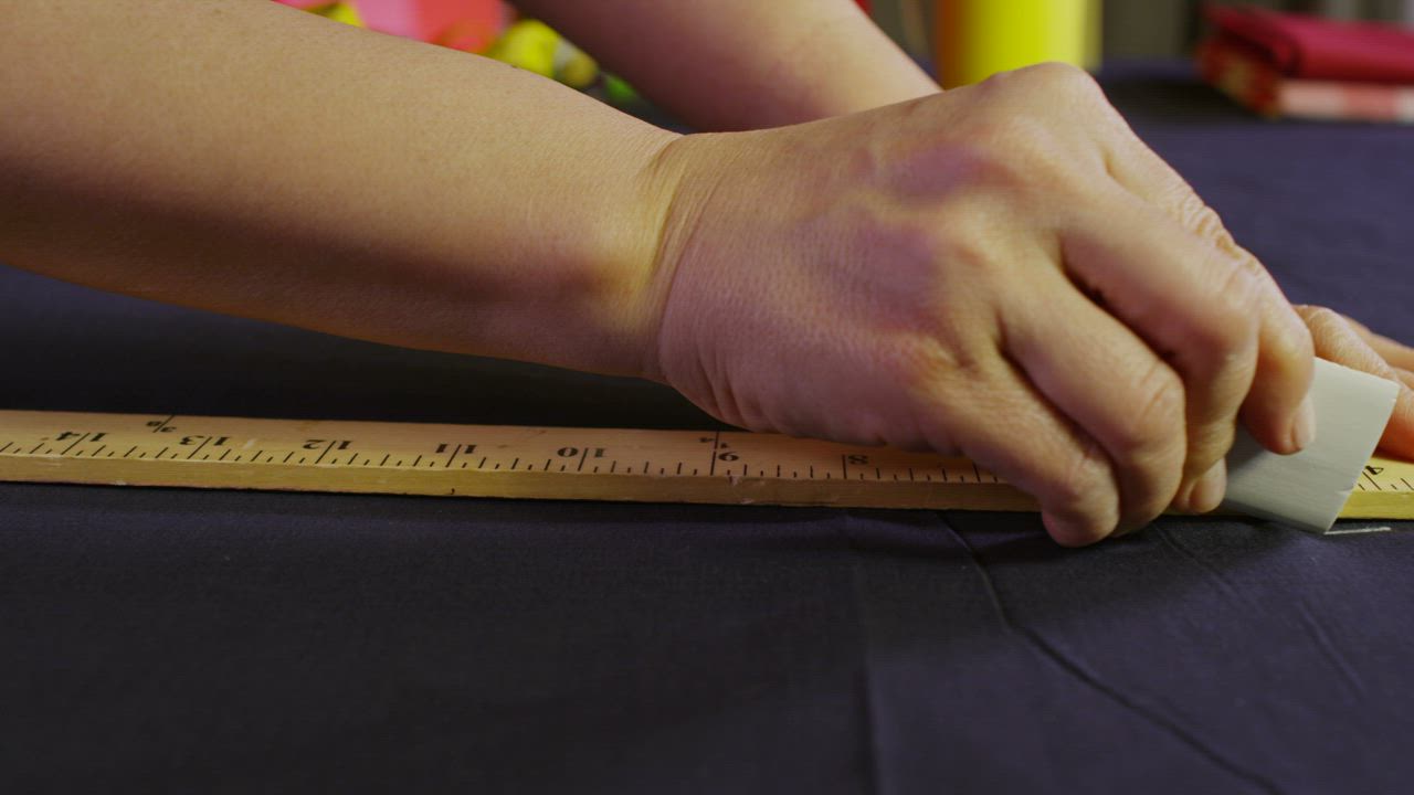 Tailor cutting along a measuring tape - Free Stock Video