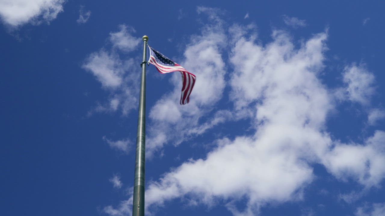 Clouds behind the American flag - Free Stock Video