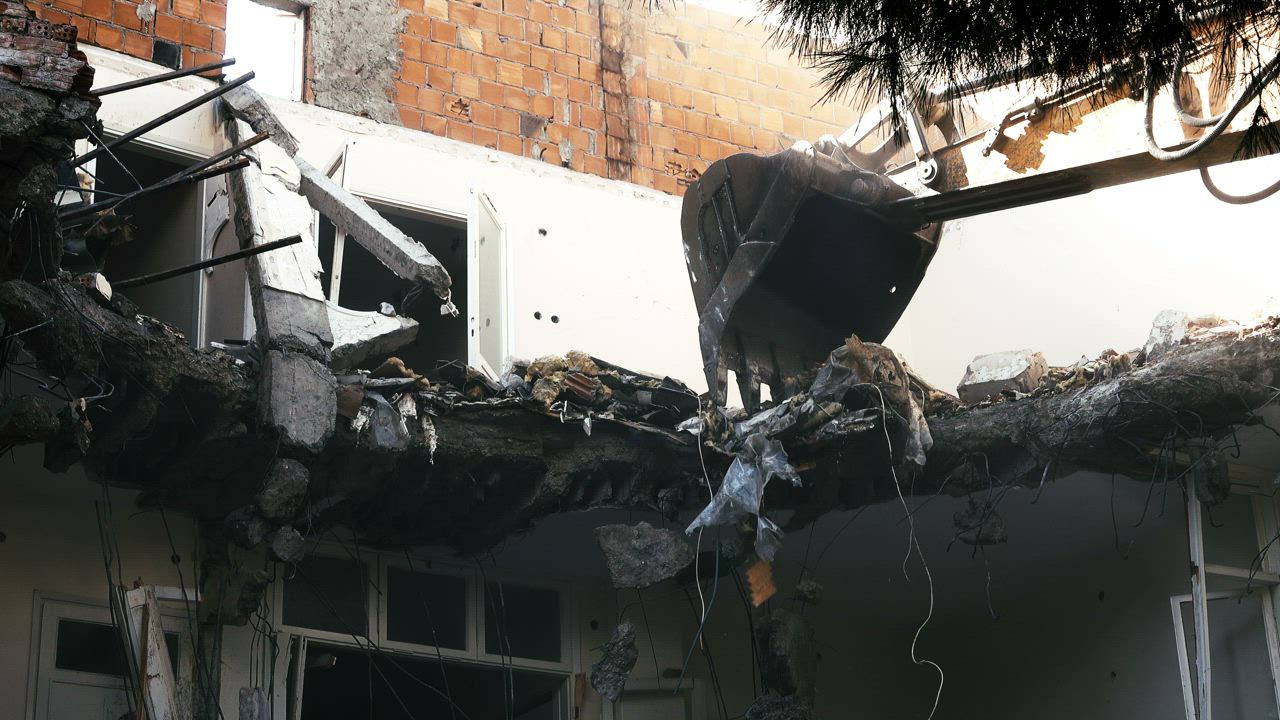 Bulldozer knocking down a ruined building - Free Stock Video