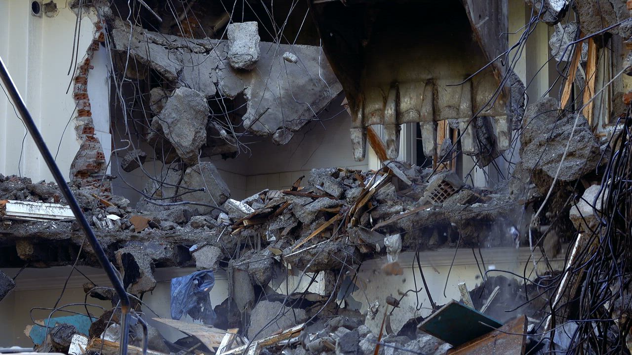 Mechanical arm of a bulldozer knocking down debris - Free Stock Video