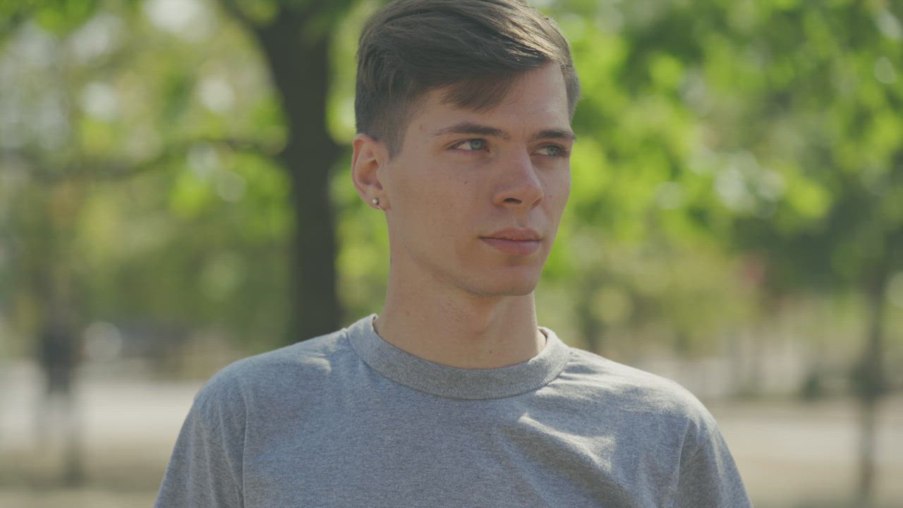Millennial man smiles at camera in outdoor portrait - Free Stock Video
