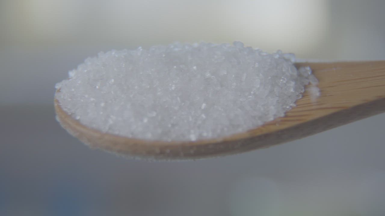 Closeup of sugar spilling from wooden spoon - Free Stock Video