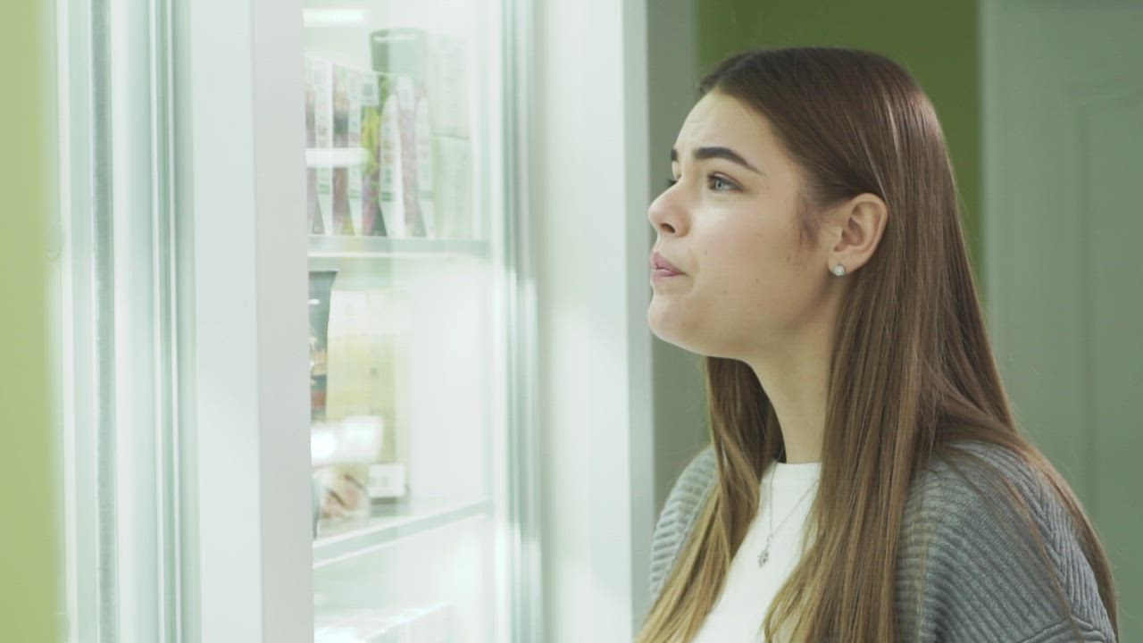 Young woman winces and rubs face in pain - Free Stock Video