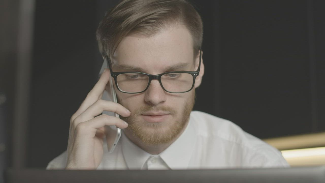 Worried man on phone call stares at laptop - Free Stock Video