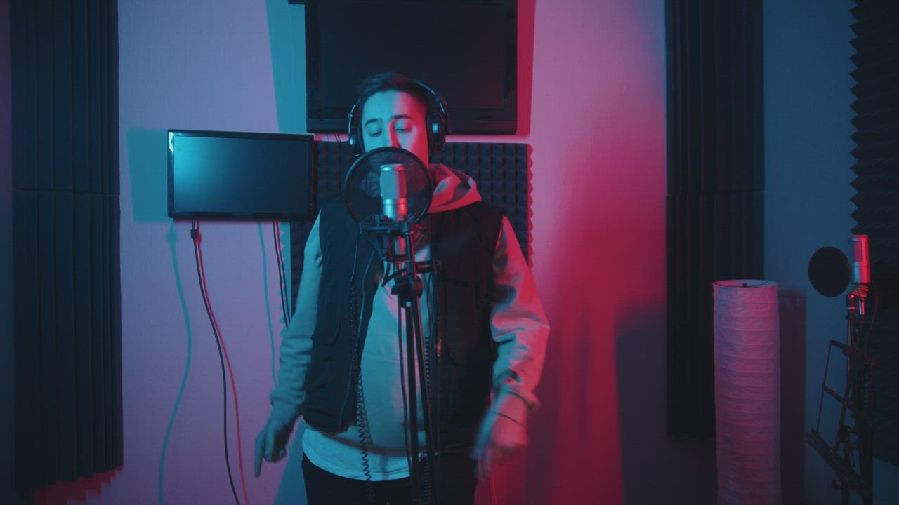 A young man in hoodie rapping in the studio - Free Stock Video