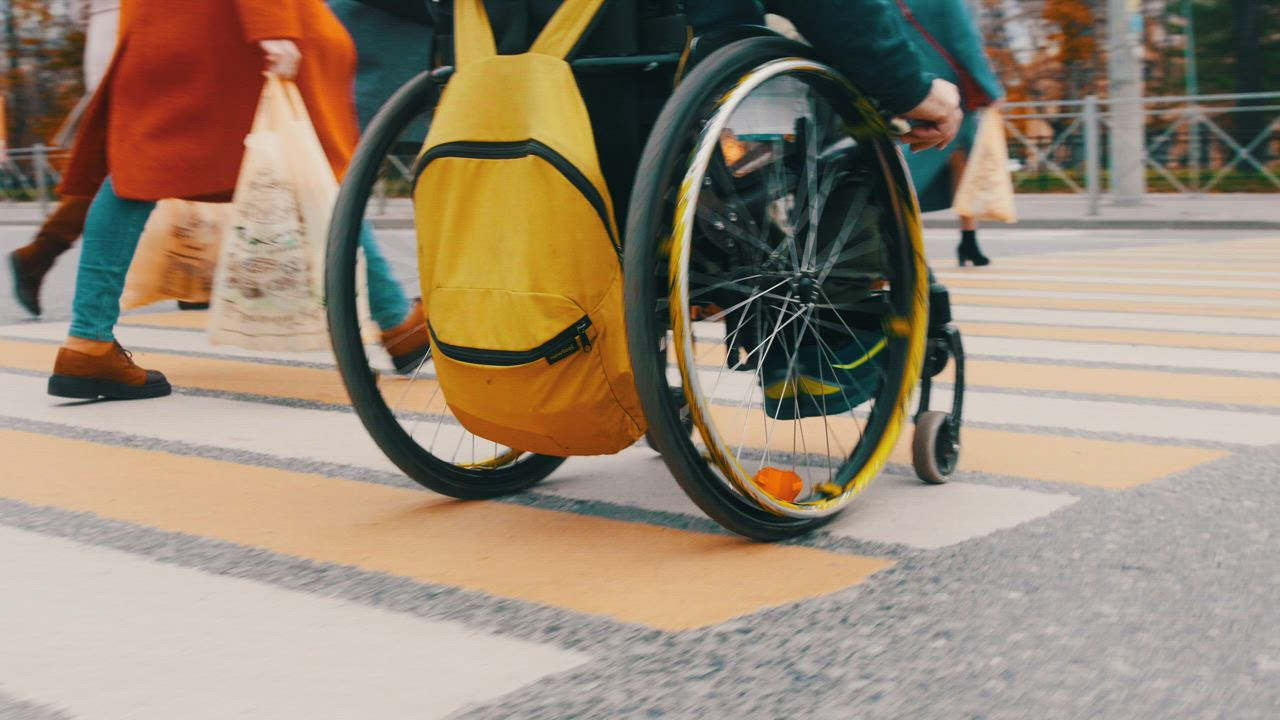 Disabled man on a wheelchair on pedestrian crossing - Free Stock Video