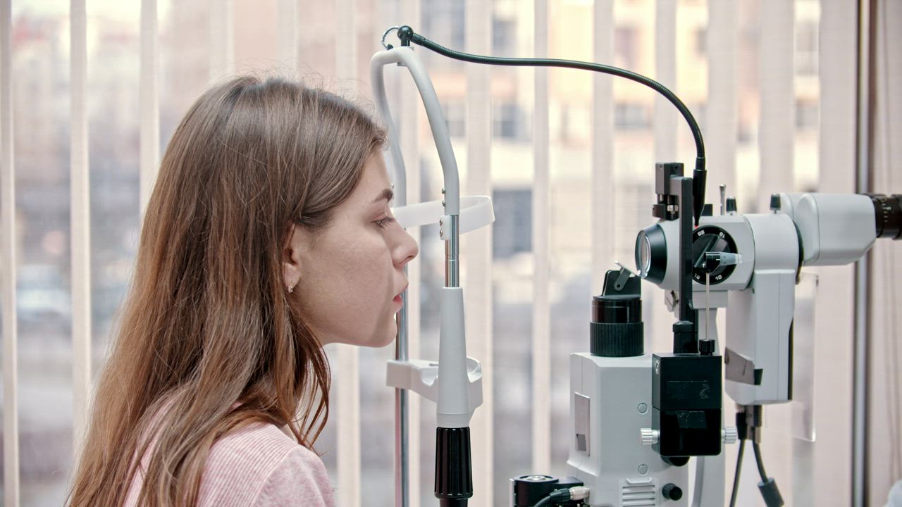 Woman putting chin on a modern vision test device - Free Stock Video